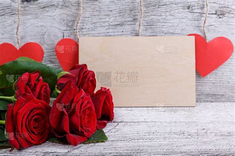 特写红玫瑰带纸信封以红心为背景寓意节日