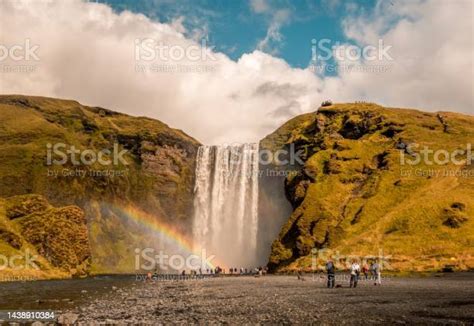 Skogafoss 아이슬란드의 옆에 무지개를 들고 폭포 근처에 서있는 사람들의 아름다운 사진 강에 대한 스톡 사진 및 기타