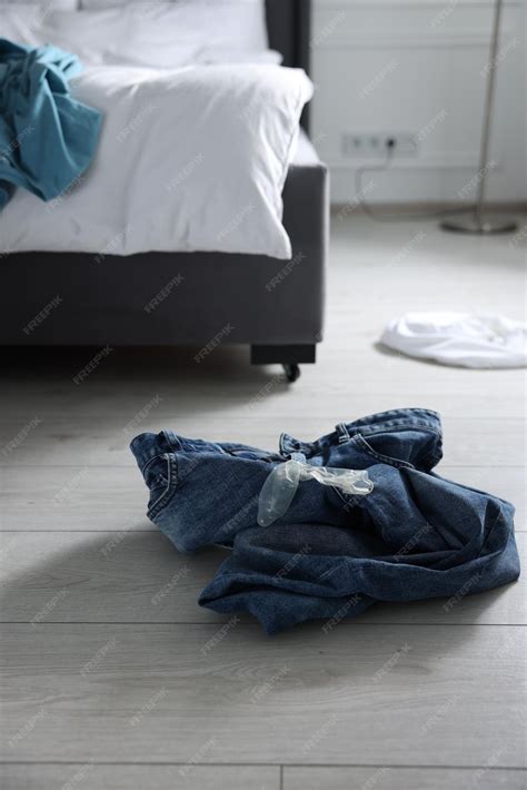 Premium Photo Unrolled Condom And Jeans On Floor In Bedroom Safe Sex