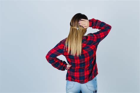 Mujer Joven Manteniendo La Mano Detrás De La Cabeza En Camisa A Cuadros
