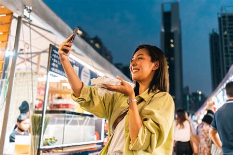 아시아 여자는 야시장에서 길거리 음식에 감자튀김을 먹는 것을 즐긴다 여행자 아시아 블로거 여성 행복한 관광객 전통적인 태국 방콕 음식을 가진 아름다운 여성 거리에 대한 스톡