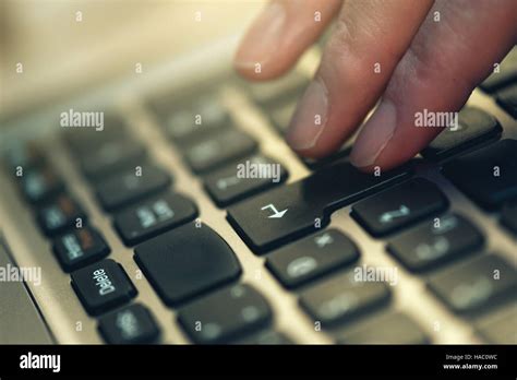 Finger Pressing Enter Key On Laptop Computer Keyboard Close Up