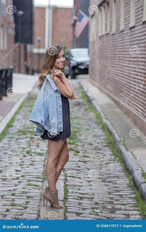 Beautiful Young Woman Poses In City Wearing Short Black Dress Stock