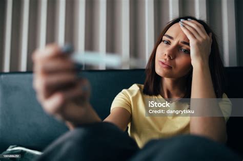 독감 바이러스가 있는 여성은 온도계로 온도를 측정하고 이마를 만지는 침대에 누워 있습니다 두통에 대한 스톡 사진 및 기타 이미지