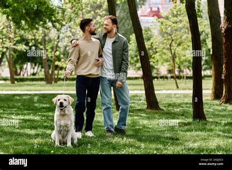 A Bearded Gay Couple Walks Hand In Hand Through A Green Park With Their