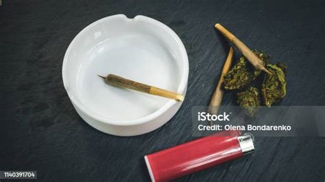 마리화나 새싹과 관절은 어두운 회색 배경에 거짓말 마리화나는 약입니다 대마초 근처 흰색 재떨이 및 Ligter 0명에 대한 스톡