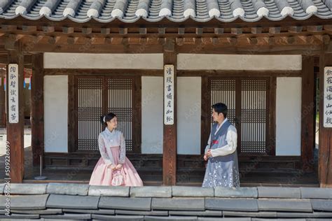 한국의 전통 가옥을 배경으로 한복을 입은 젊은 남녀 커플 또는 대학생 아시아 한국 남녀 모델 Foto De Stock
