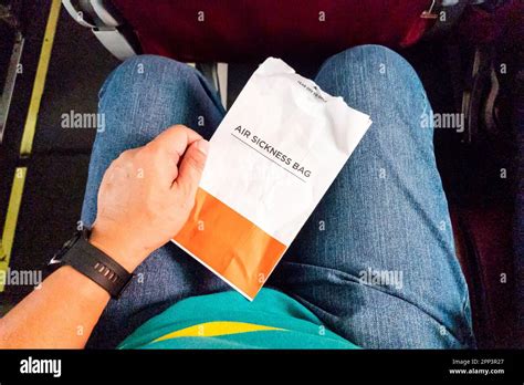 Passanger Holding Air Sickness Bag During Air Flight Incase Need To