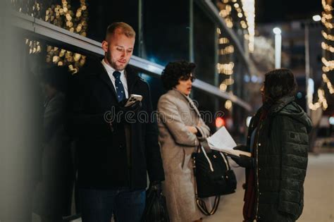 Busy Urban Evening Scene With People Waiting At A Bus Stop In Winter