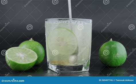Shot Of Hand Pouring Cold Tequila From A Bottle With Lemon And Salt On