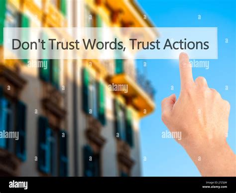 Don't Trust Words, Trust Actions - Hand pressing a button on blurred background concept ...
