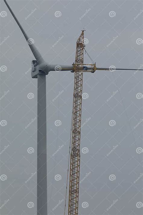 A Crawler Crane Is Hoisting A Rotor Blade Of A New Wind Turbine Stock