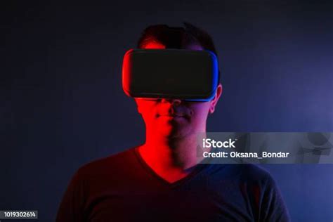 젊은 남자 Vr 헤드셋 착용 하 고 경험 하는 가상 현실 검은 바탕에 빨간색 듀얼 파란색 빛 3차원 형태에 대한 스톡 사진 및