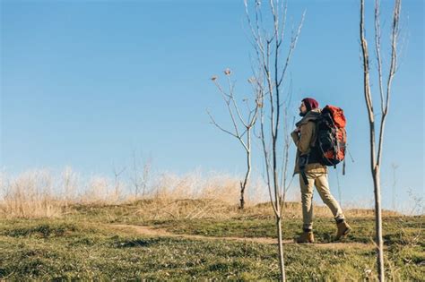 Hombre hipster viajando con mochila en el bosque de otoño con chaqueta