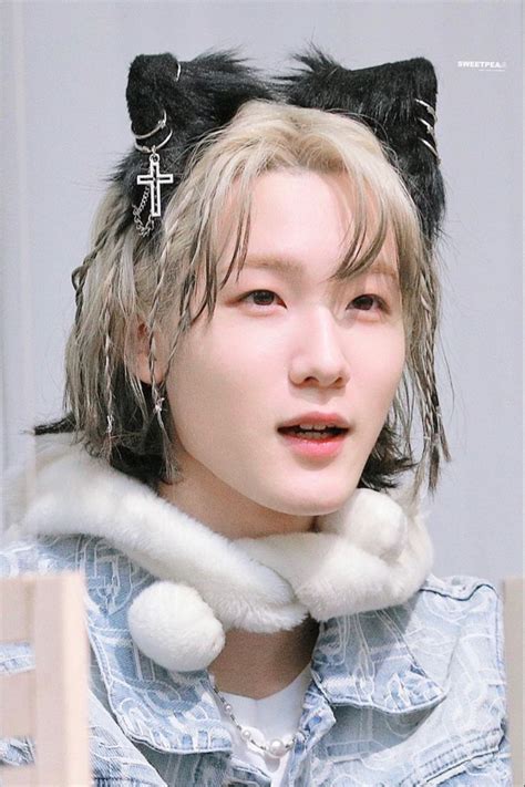 A Person Wearing A Cat Earring And A Denim Jacket With White Fur On It