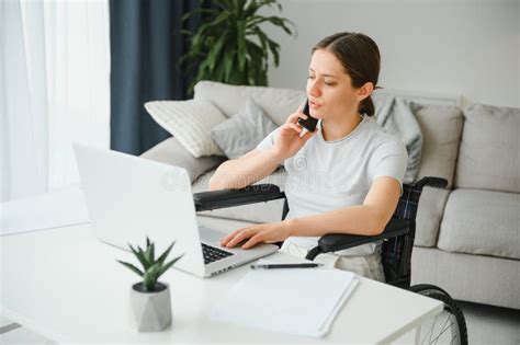 Female Freelance Programmer Sitting In Wheelchair And Using Computers