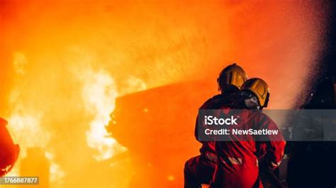 물과 소화기로 불길과 싸우는 용감한 소방관들 팀워크와 용기로 화재를 진압하는 소방관 강도 높은 소방 훈련 2명에 대한 스톡 사진 및 기타 이미지 Istock