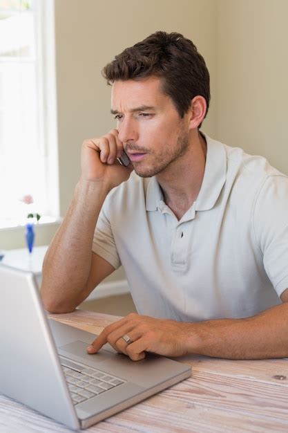 Homem Usando Laptop E Celular Em Casa Foto Premium