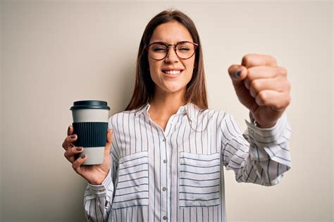 젊은 아름 다운 갈색 머리 여자 마시는 컵 의 테이크 아웃 Coffe 위에 흰색 배경 짜증나고 좌절 외침 으로 분노 미친 고함