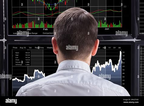 Side View Of A Young Male Stock Market Broker Analyzing Graphs On