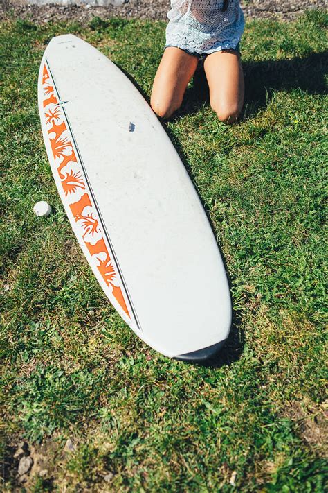 Woman Waxing Her Surfboard By Stocksy Contributor Michela Ravasio
