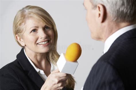 Female Journalist With Microphone Interviewing Businessman Stock Image