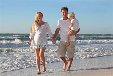 Lycklig Familj Av Tre Personer Som Går På Stranden Längs Havet Fotografering För Bildbyråer