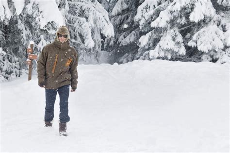 西方人一个人走笑微笑横图室外白天正面树林雪植物大雪帽子欧洲欧洲人仅一个男性仅一个人服装装饰墨镜眼镜