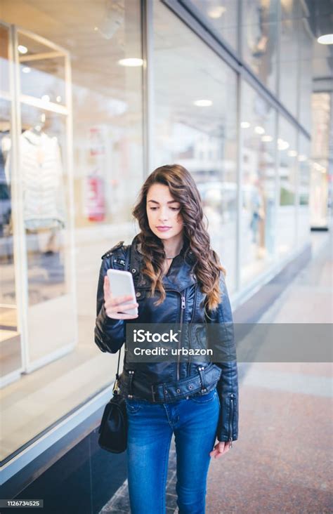 도시를 산책 하는 아름 답 고 세련 된 여자 근처 상점 창 고 그녀의 휴대 전화를 사용 합니다 20 29세에 대한 스톡 사진 및 기타 이미지 Istock