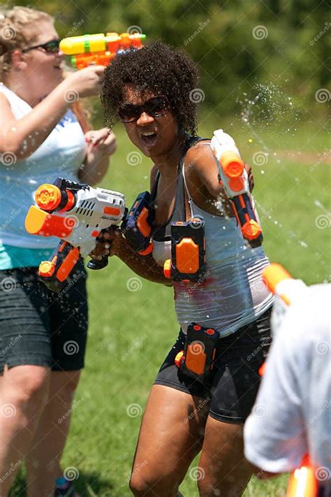 Woman Squirts People In Group Water Gun Fight Editorial Stock Image