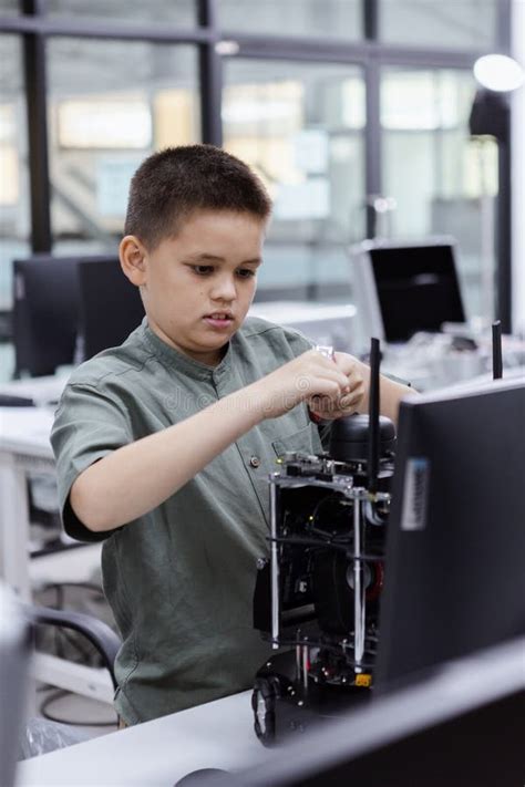 Boy Learning To Repair Electrical Appliances Education On Table At
