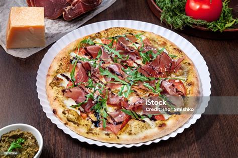 토마토 파마산 치즈와 프로 슈 토와 함께 피자에 탑 뷰 화이트 소스와 함께 갈색 나무 테이블에 포함 조리법 또는 메뉴에 대 한