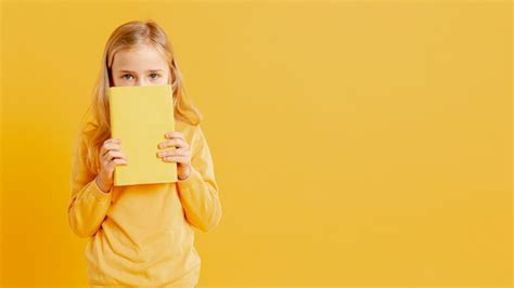Menina Cobrindo O Rosto Com O Livro Foto Premium