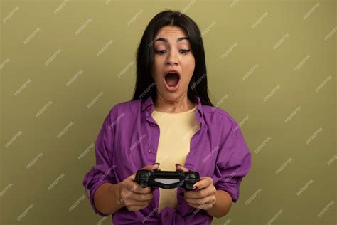 Free Photo Excited Pretty Brunette Woman Holds And Looks At Game
