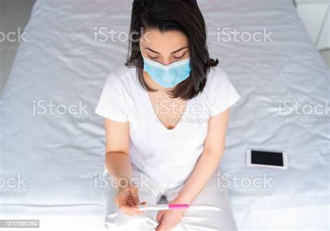 코로나 검역소에서 집에서 임신 검사를 받고 있는 보호 얼굴 마스크를 가진 젊은 여성 위험 요소에 대한 스톡 사진 및 기타 이미지