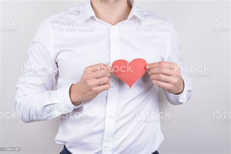 쾌활 한 잘생긴 꿈 꿈꾸는 좋은 사랑 스러운 귀여운 부드러운 다행 긍정적인 웃는 남자의 심장 근처 가슴 절연 회색 배경 들고