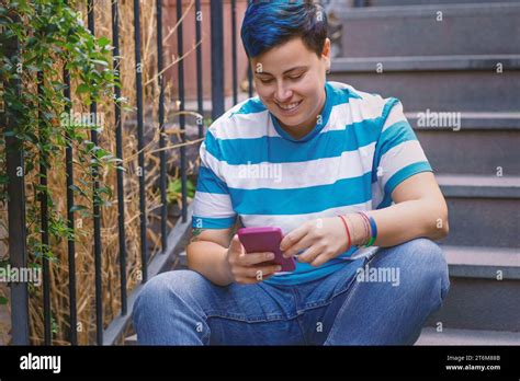 Non Binary Person In Striped Attire Engaged With Smartphone