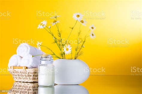 카모마일 꽃 흰색 꽃병에 서 있다 롤으로 압 연 3 흰 수건 바구니에 거짓말 크림 항아리 배경은 노란색 이다 정 0명에 대한