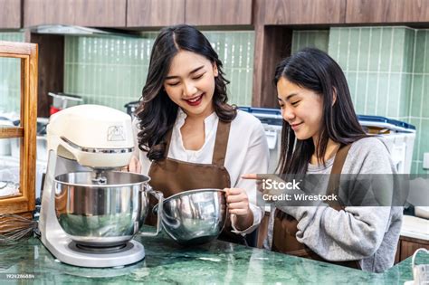 두 명의 젊은 아시아 여성 친구와 컵 케이크 크림을 만드는 앞치마 전기 믹서 사용 2명에 대한 스톡 사진 및 기타 이미지 2