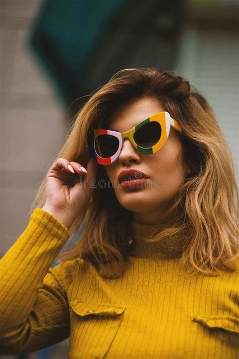 Attractive Female Model Wearing A Beautiful Yellow Dress And Sunglasses
