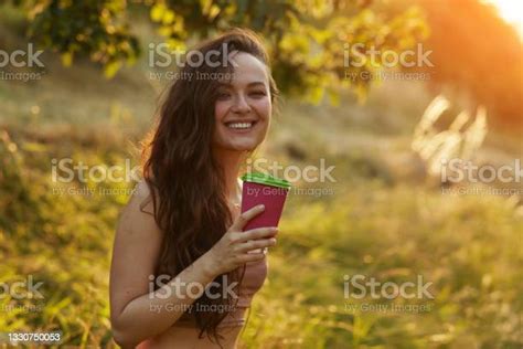 공원에서 젊은 아름다운 미소 여자와 텍스트 골든 아워 여유 공간에서 나무와 부시 배경에 커피 또는 차와 종이 컵을 들고 25 29세에 대한 스톡 사진 및 기타 이미지