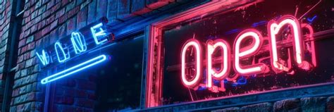 Bright Neon Signs Illuminating A Nighttime Street In A Cozy Urban