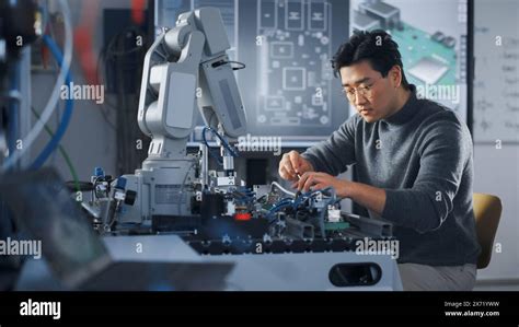 Asian Student Assembling Robotic Arm With Screwdriver During The Lesson