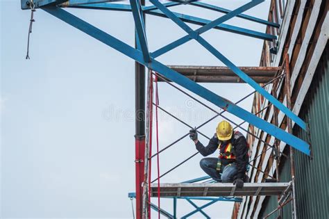 Construction Worker Wearing Safety Harnesses On Scaffolding At Construction Site Working At