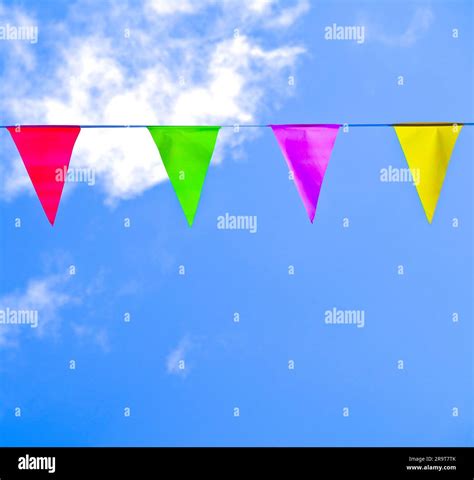 Bright Colorful Triangle Flags On A String Blue Sky With White Fluffy