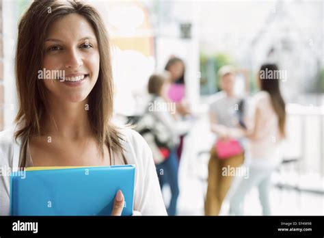 Pretty Student Smiling And Holding Notepads Stock Photo Alamy