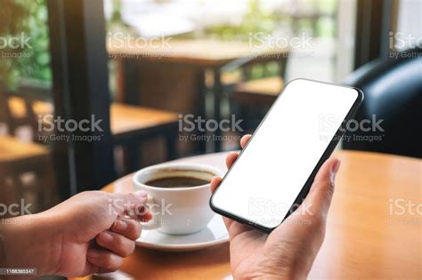 커피를 마시는 동안 빈 데스크톱 화면으로 검은 색 휴대 전화를 들고 손을 가득 찬에 대한 스톡 사진 및 기타 이미지 가득 찬