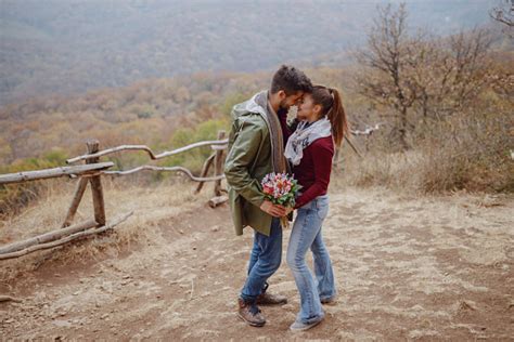 가을에 자연에 서있는 동안 사랑에 귀여운 다문화 커플 남자 주는 그의 여자 친구 꽃다발 가을에 대한 스톡 사진 및 기타 이미지