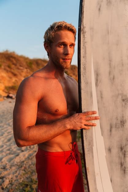 Premium Photo Caucasian Shirtless Surfer Man Holding His Surfboard By Ocean At Sunrise