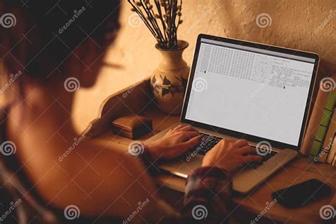 Back View Of Caucasian Female Programmer Siting At Desk Using Laptop With Coding On Screen